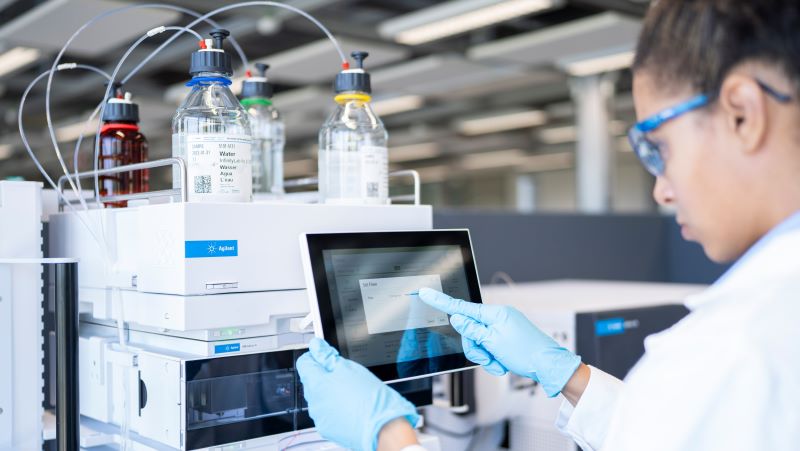 Scientist in a lab looks at the screen for the InfinityLab Assist UI ...