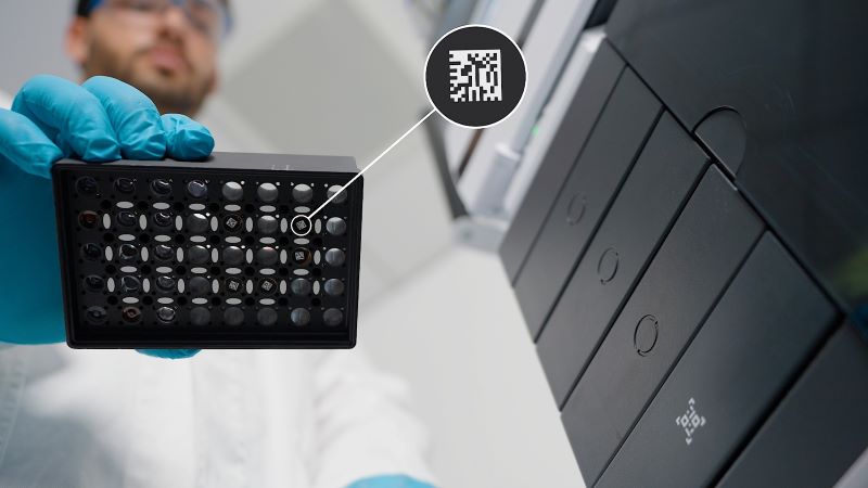 A scientist works on the InfinityLab Sample ID Reader. The scanner ...